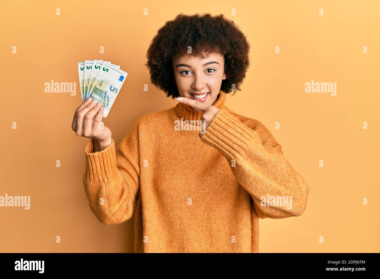 Young hispanic girl holding bunch of 5 euro banknotes smiling happy ...