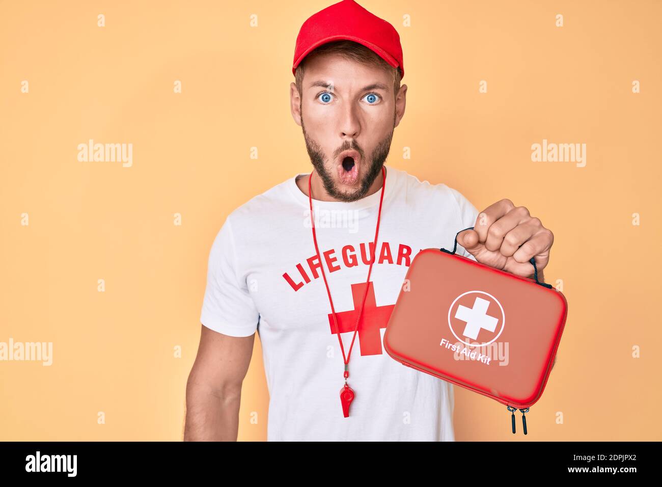 Young caucasian man wearing lifeguard t shirt holding first aid kit ...