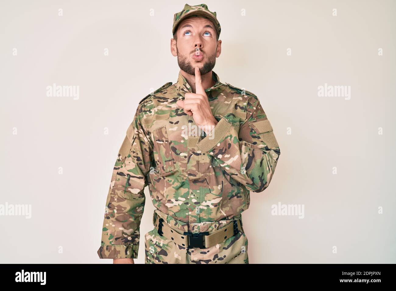 Young caucasian man wearing camouflage army uniform thinking ...