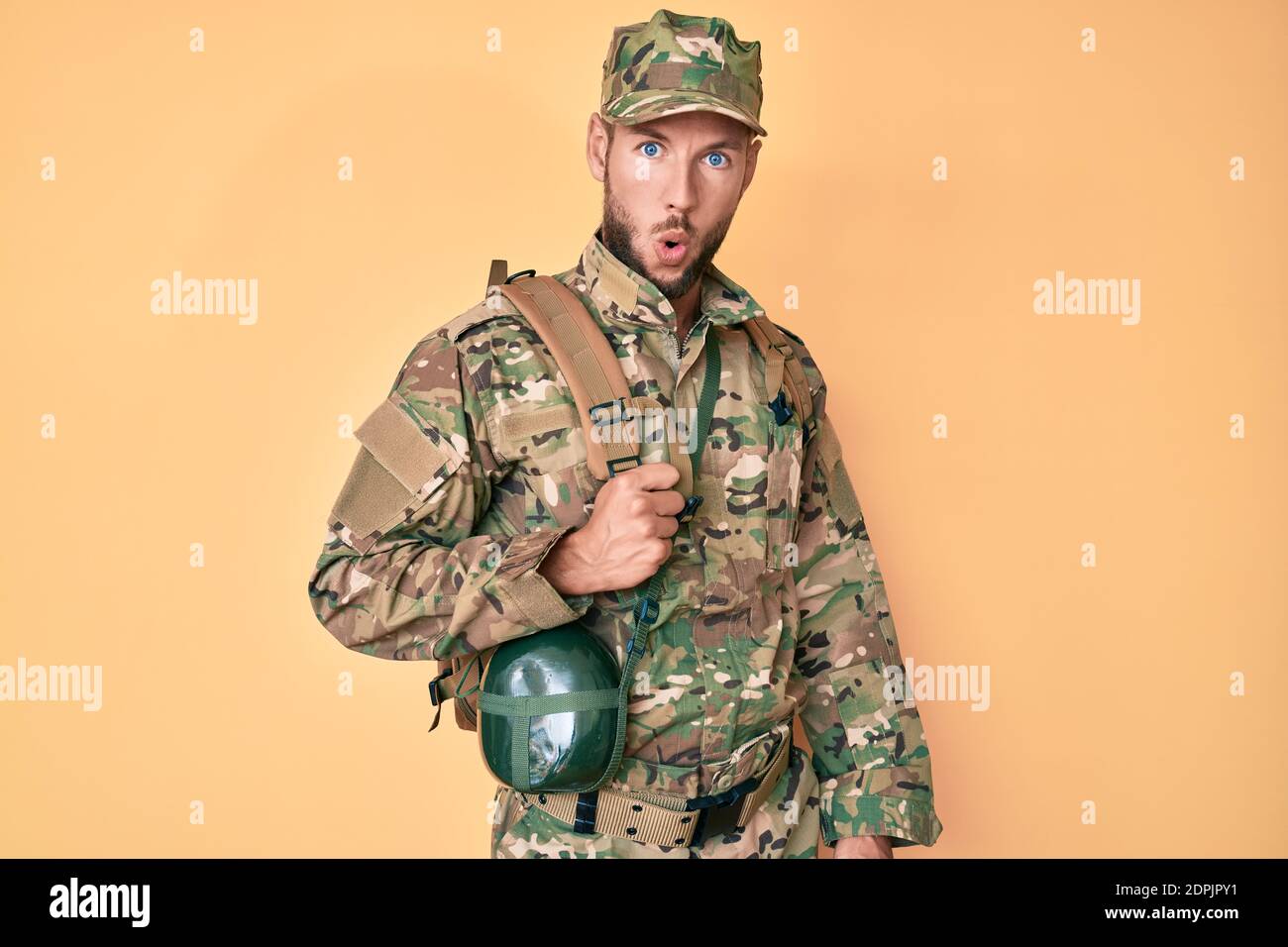 Young caucasian man wearing camouflage army uniform and canteen scared ...