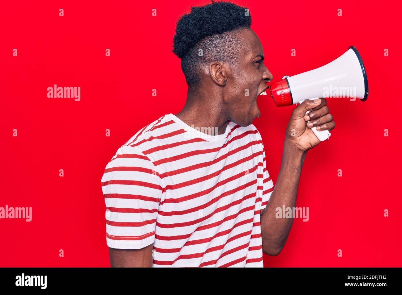 Young african man shouting angry throught megaphone Stock Photo - Alamy