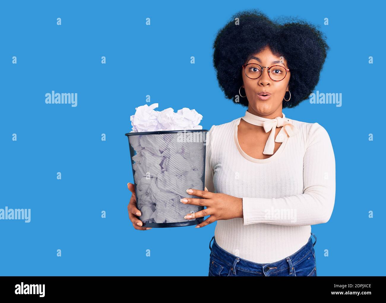 Young african american girl holding paper bin full of crumpled papers ...