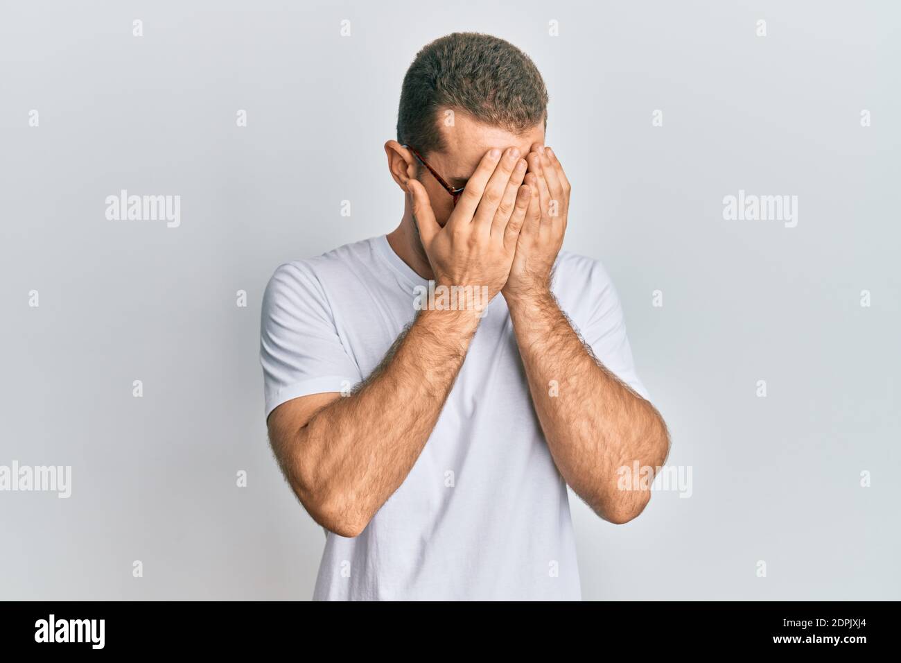 Young caucasian man wearing casual clothes and glasses with sad ...