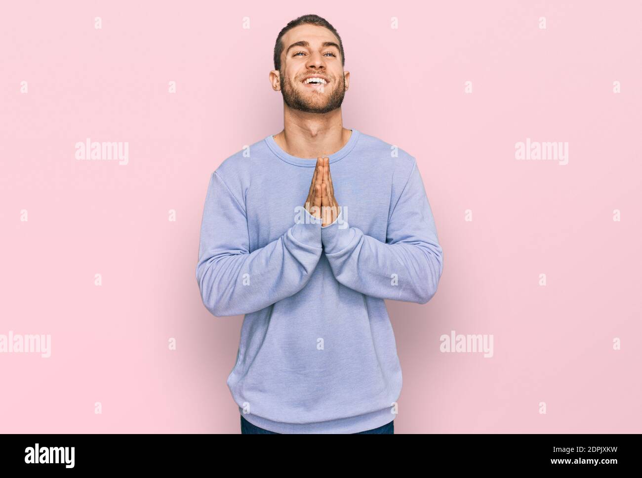 Young caucasian man wearing casual clothes begging and praying with ...