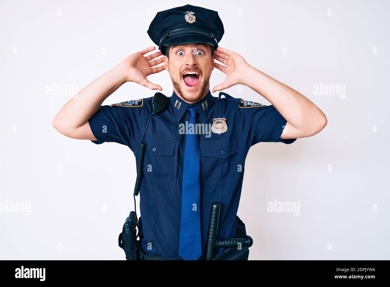 Young caucasian man wearing police uniform crazy and scared with hands ...