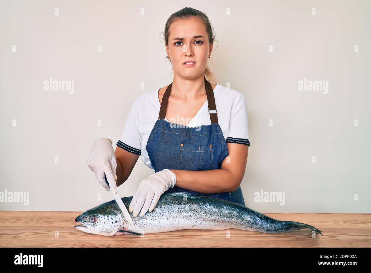 Beautiful caucasian woman fishmonger selling fresh raw salmon clueless ...