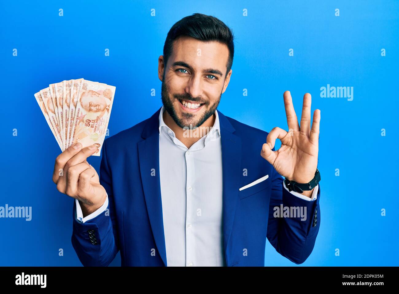 Young hispanic businessman wearing business suit holding turkish lira ...
