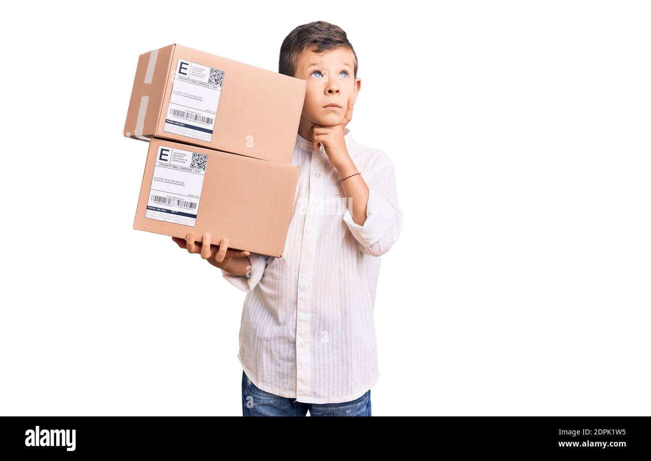 Cute blond kid holding delivery package serious face thinking about ...
