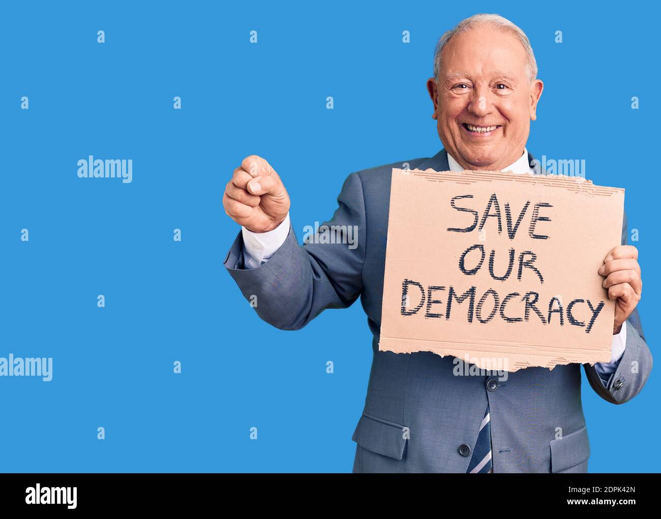 Senior handsome grey-haired man holding save our democracy cardboard ...