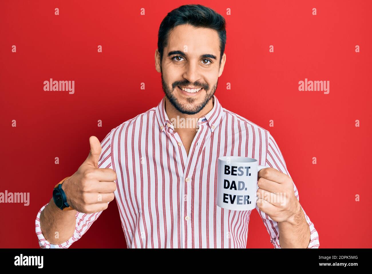 Young hispanic man drinking mug of coffe with best dad ever message ...