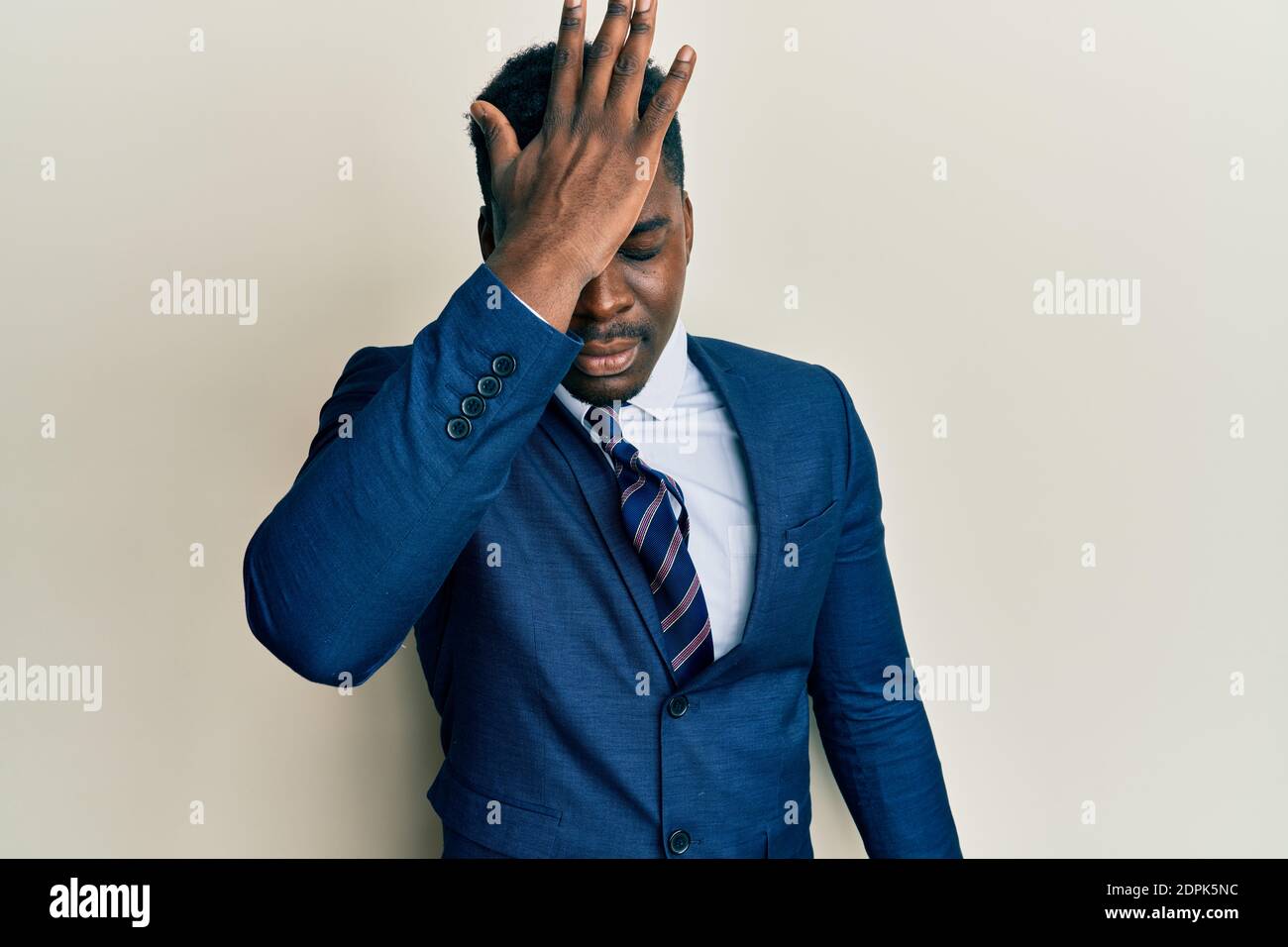 Handsome black man wearing business suit and tie surprised with hand on ...