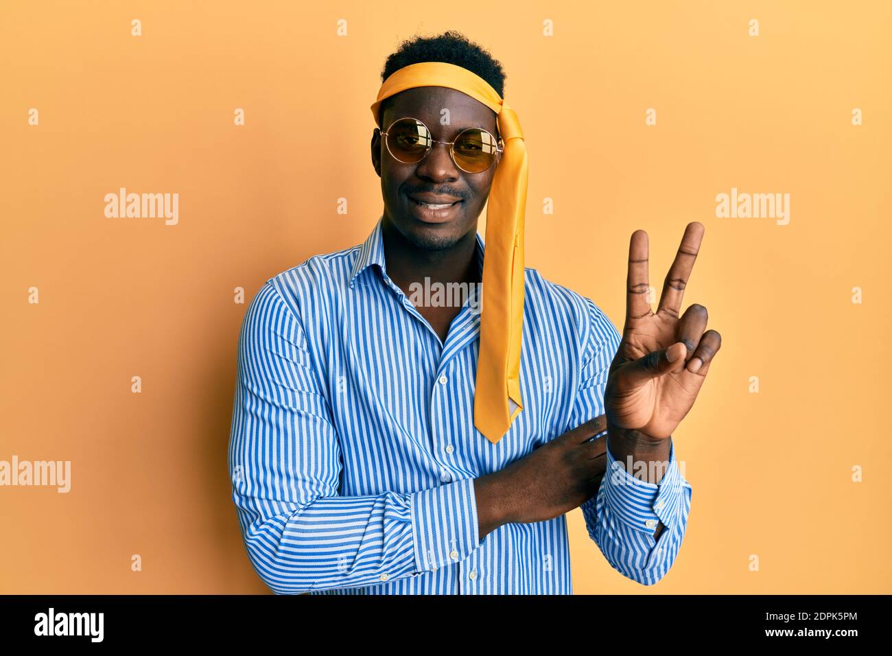Handsome black man drunk wearing tie over head and sunglasses smiling ...