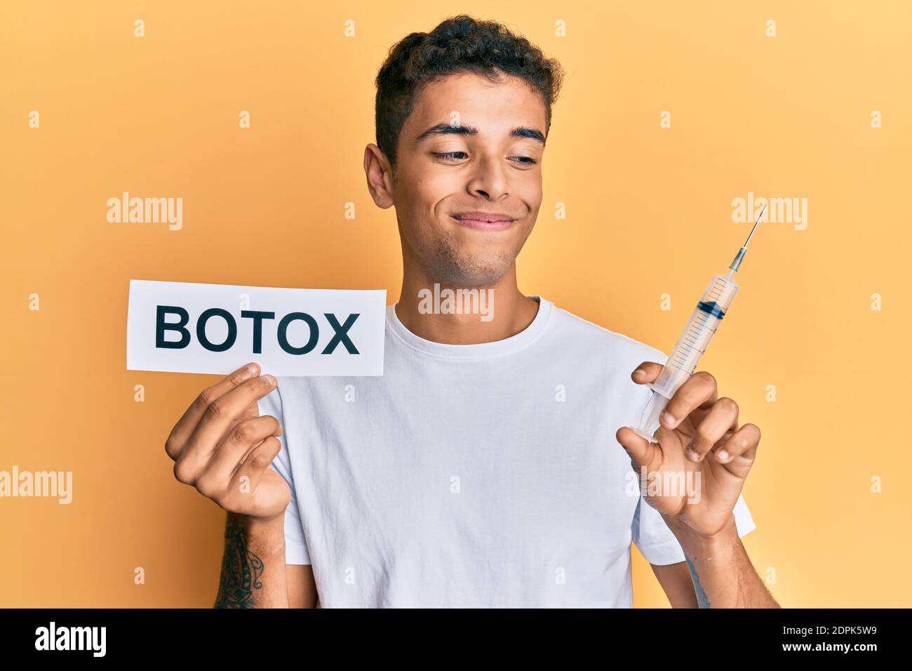 Young handsome african american man holding botox banner and needle ...