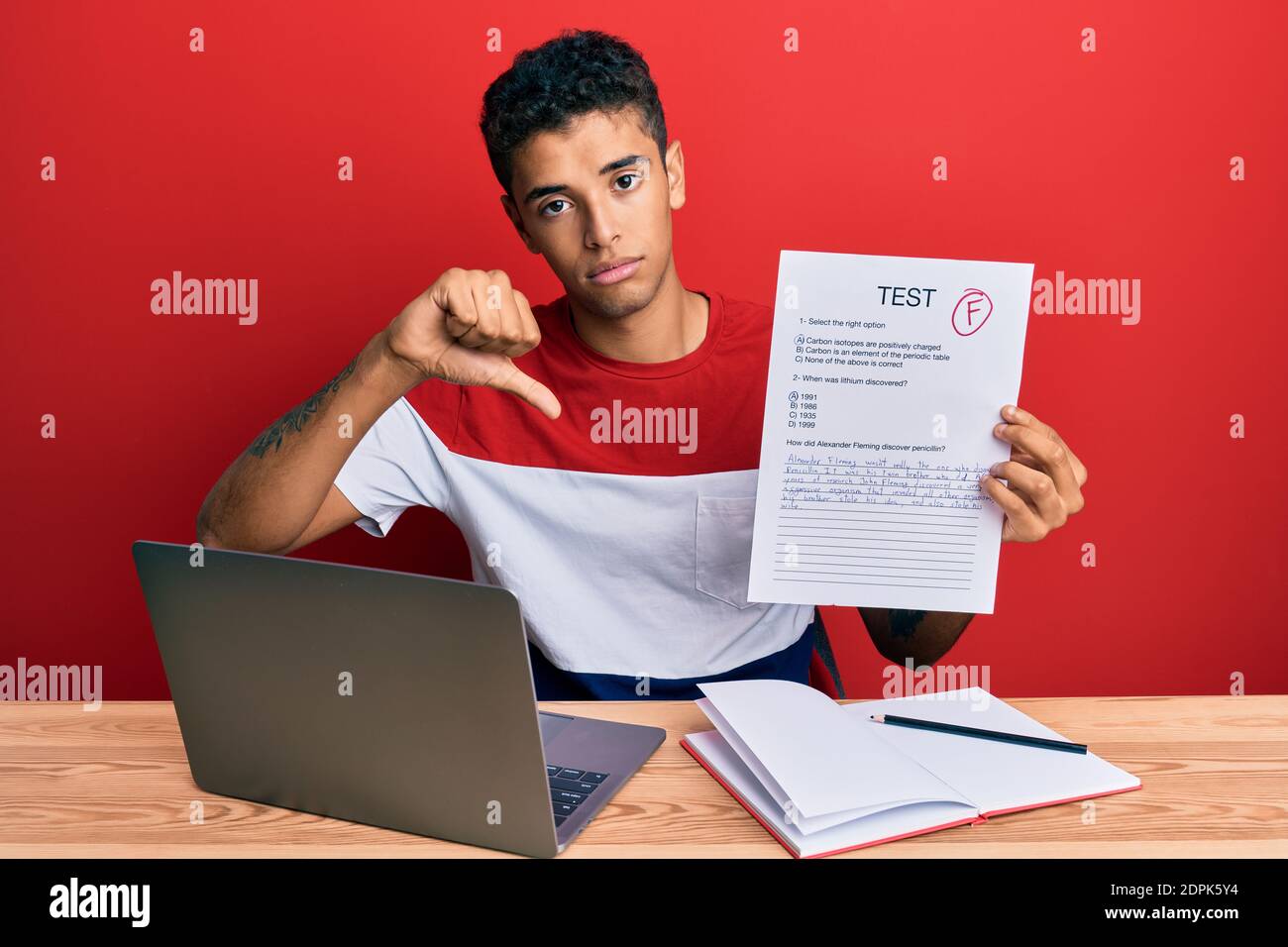 Young handsome african american man showing failed exam with angry face ...