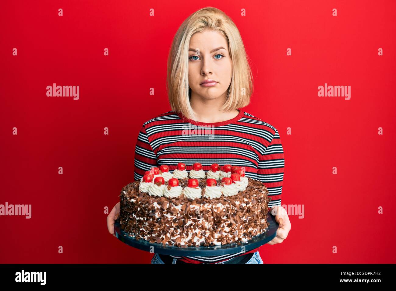 Young blonde woman celebrating birthday holding big chocolate cake ...