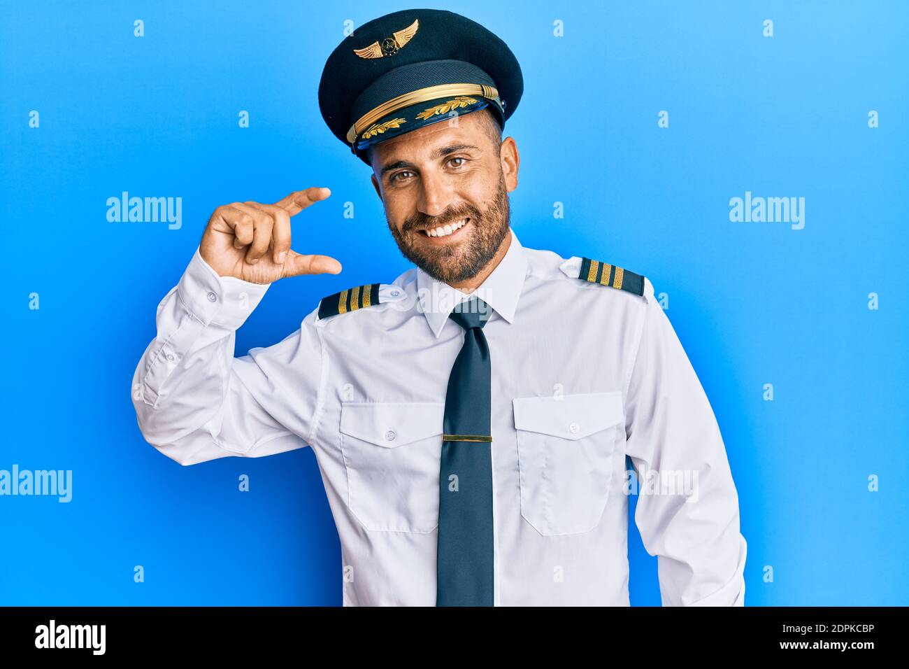 Handsome man with beard wearing airplane pilot uniform smiling and ...