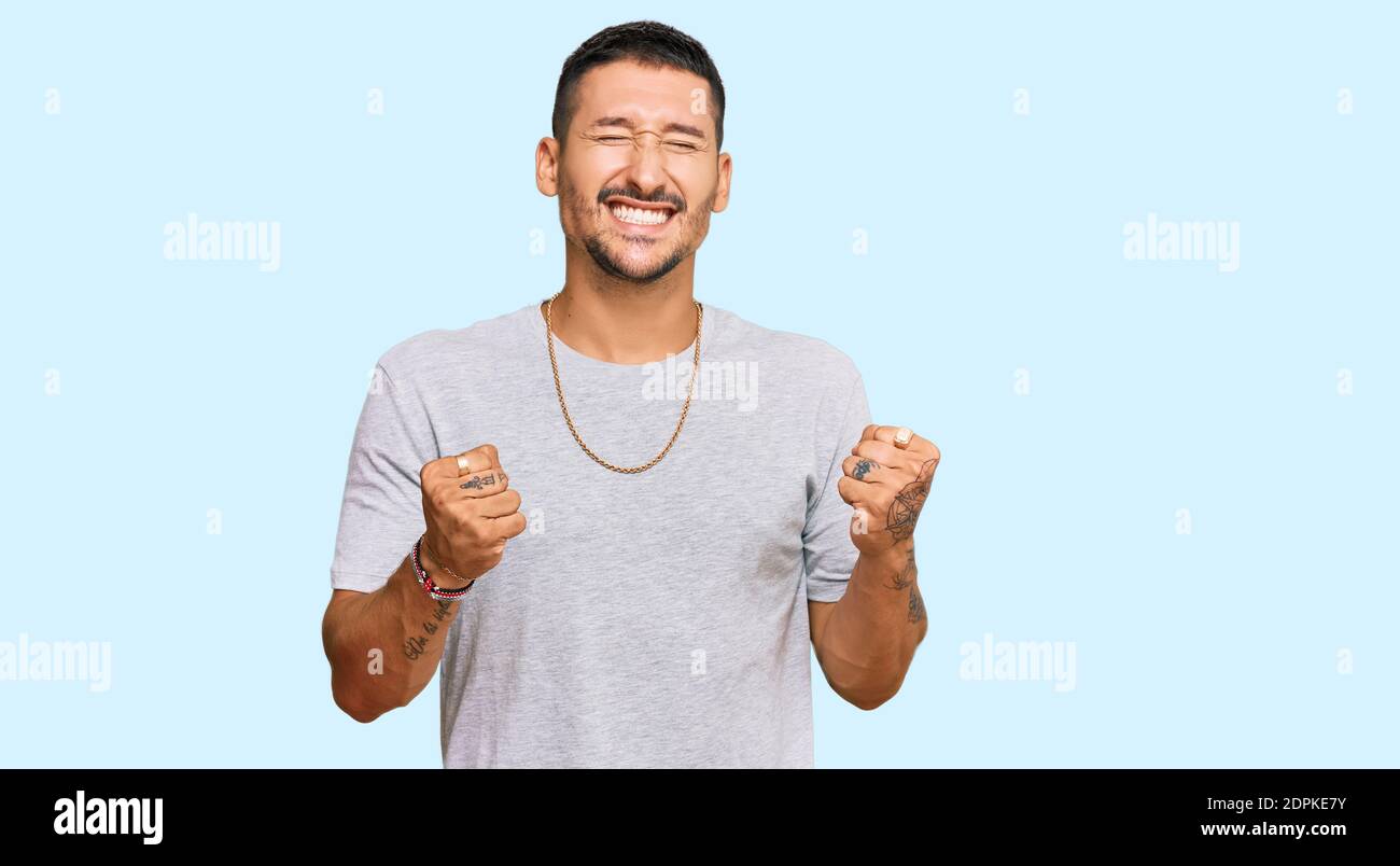 Handsome man with tattoos wearing 90s style excited for success with ...