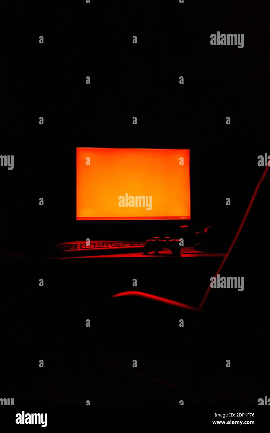 Illuminated Computer On Table In Darkroom Stock Photo - Alamy