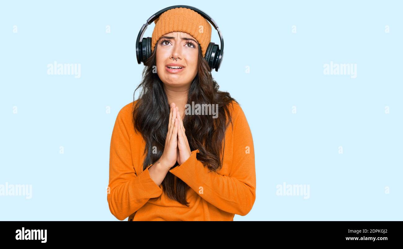 Beautiful brunette young woman listening to music using headphones ...