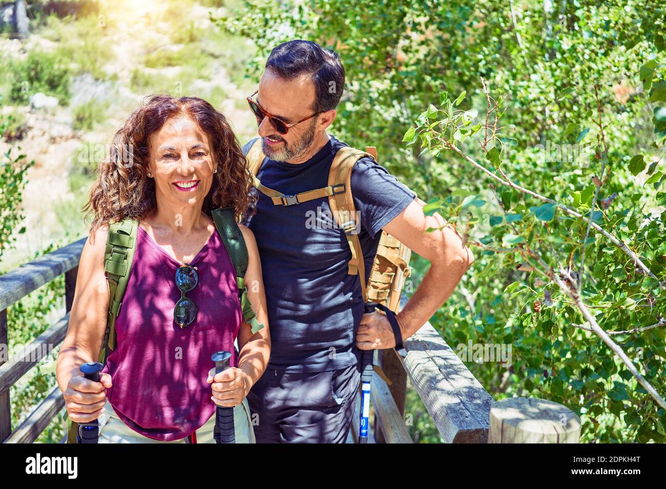 Beautiful couple of hiker wearing explorer clothes and backpack smiling ...