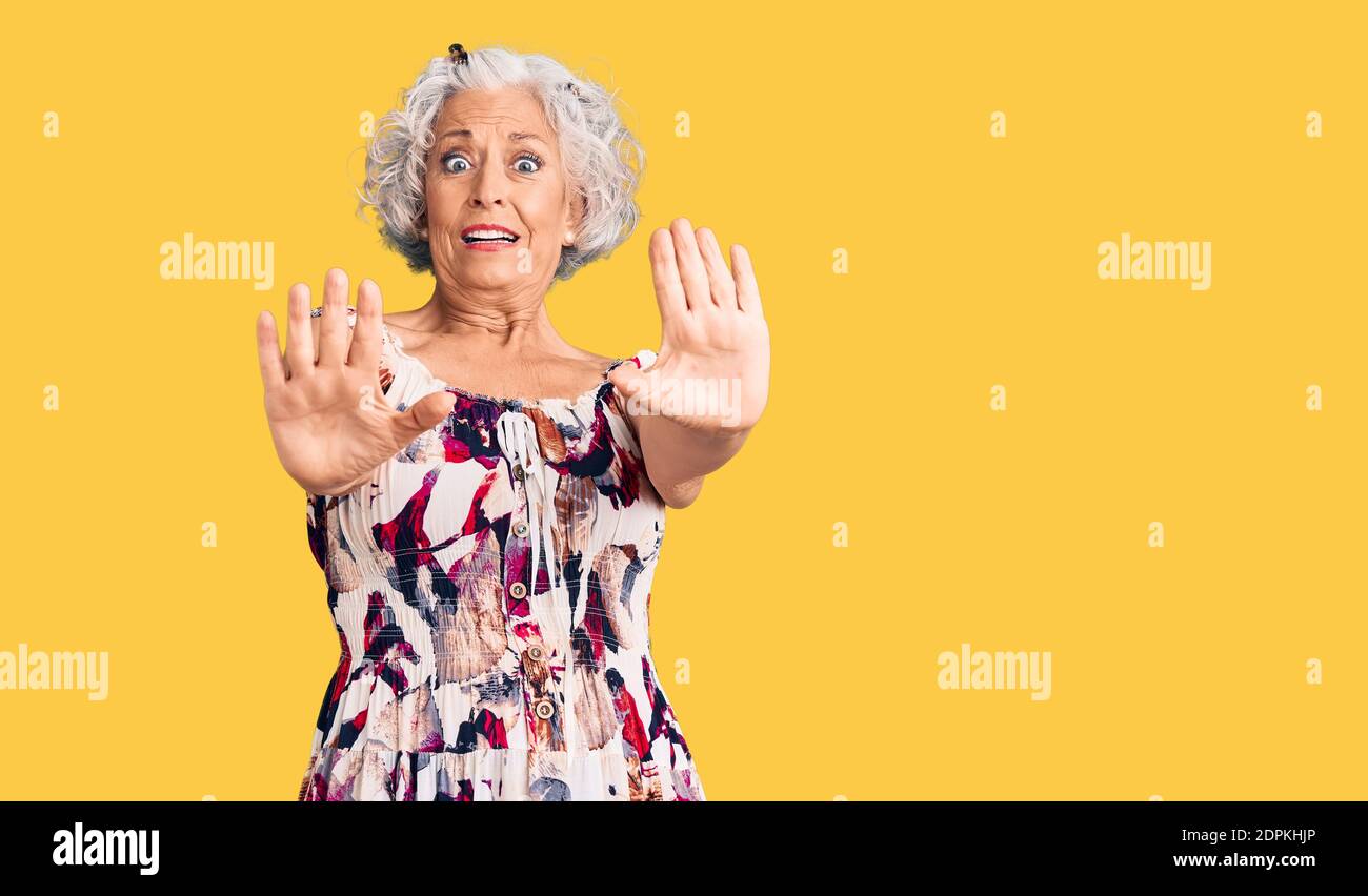 Senior grey-haired woman wearing casual clothes afraid and terrified ...