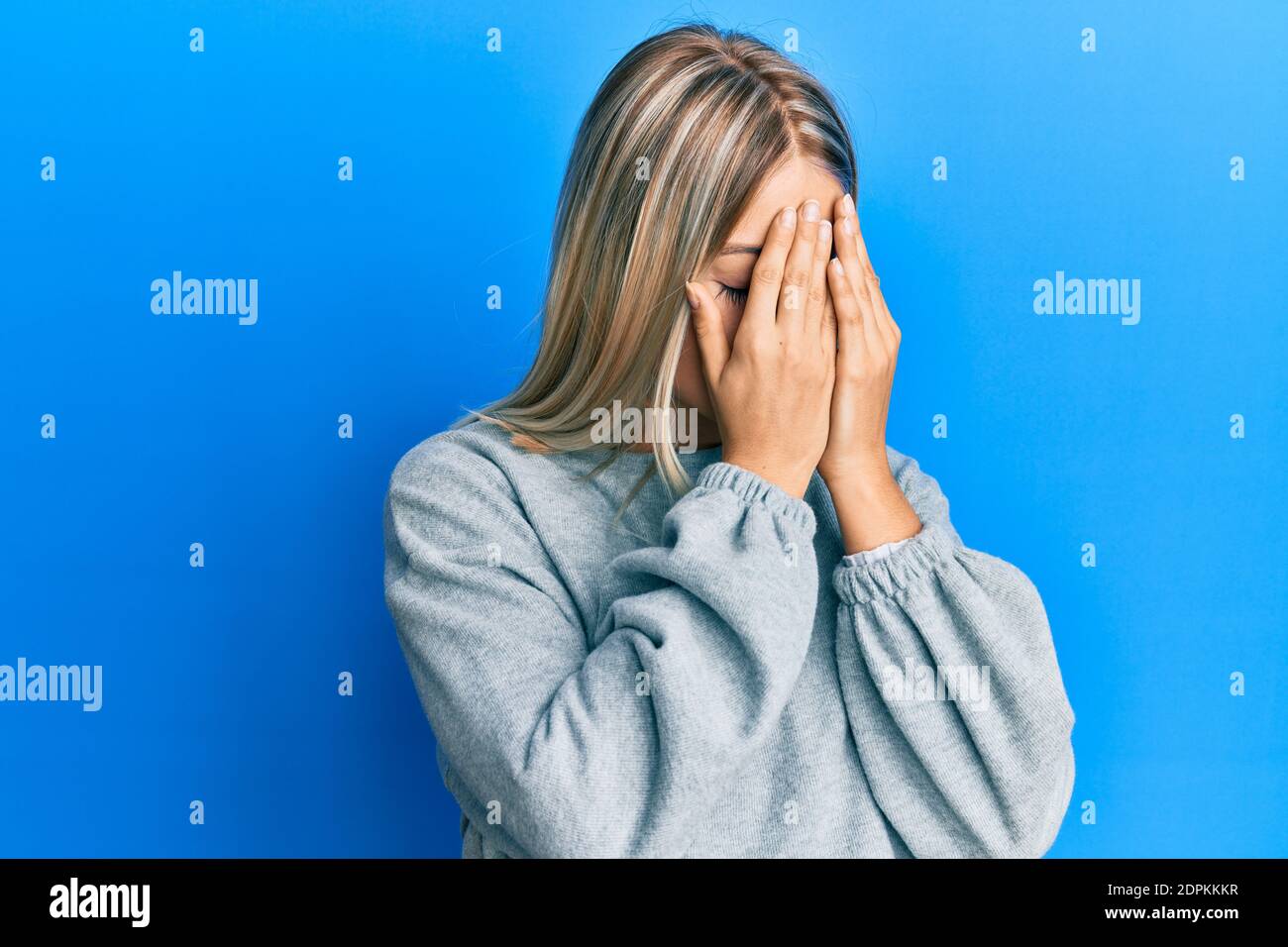 Beautiful blonde woman wearing casual clothes with sad expression ...
