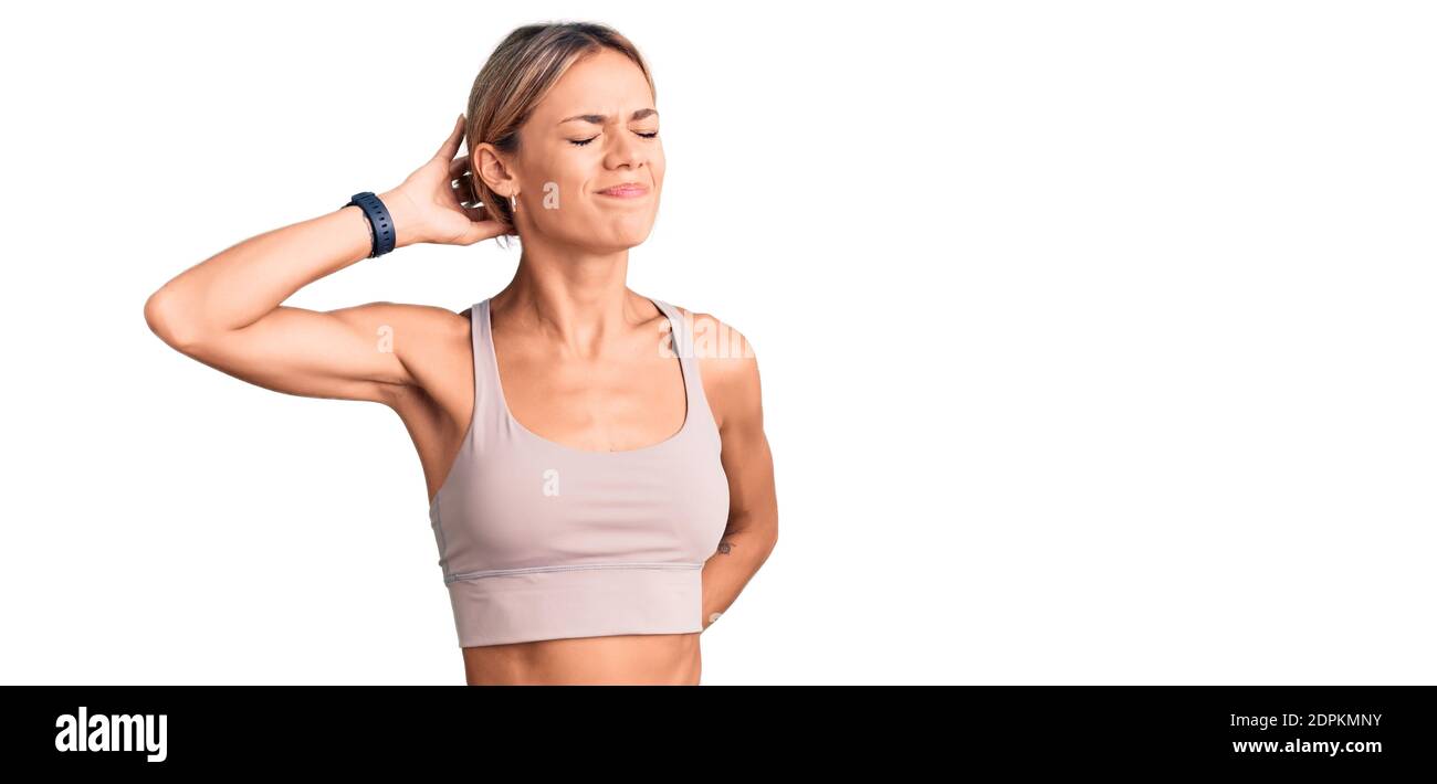 Beautiful caucasian woman wearing sportswear suffering of neck ache ...