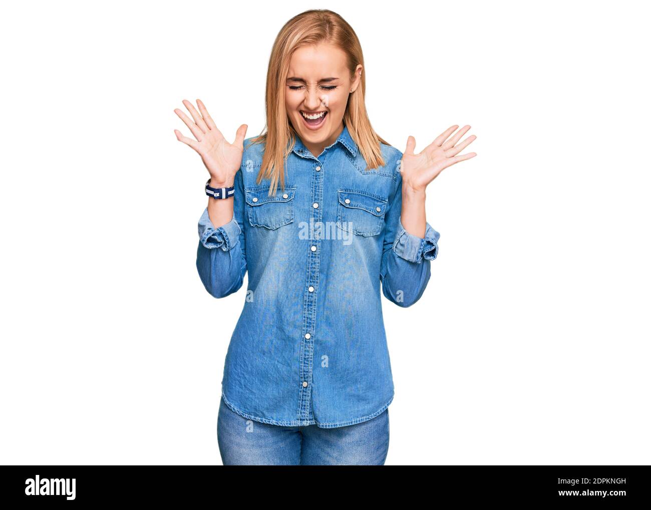Beautiful caucasian woman wearing casual denim jacket celebrating mad ...