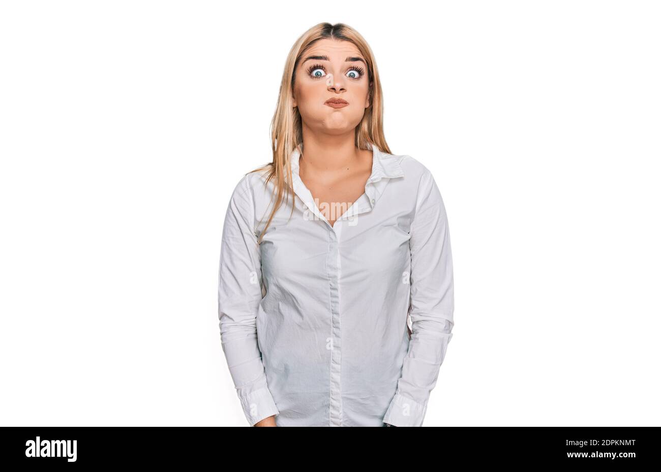 Young caucasian woman wearing casual clothes puffing cheeks with funny ...