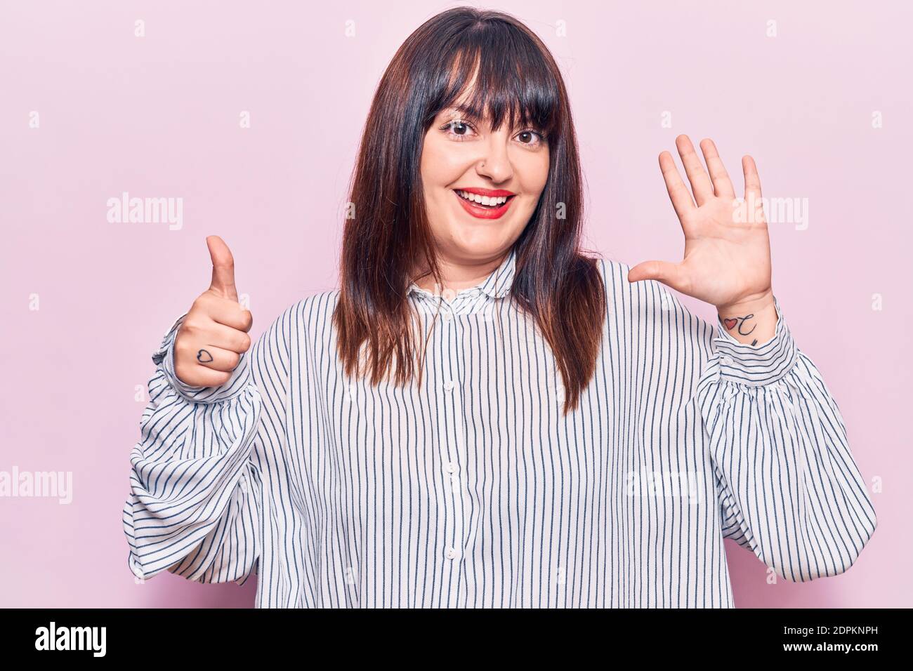 Young plus size woman wearing casual clothes showing and pointing up ...