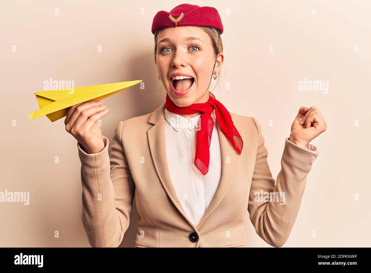 Young beautiful blonde girl wearing stewardess uniform holding paper ...