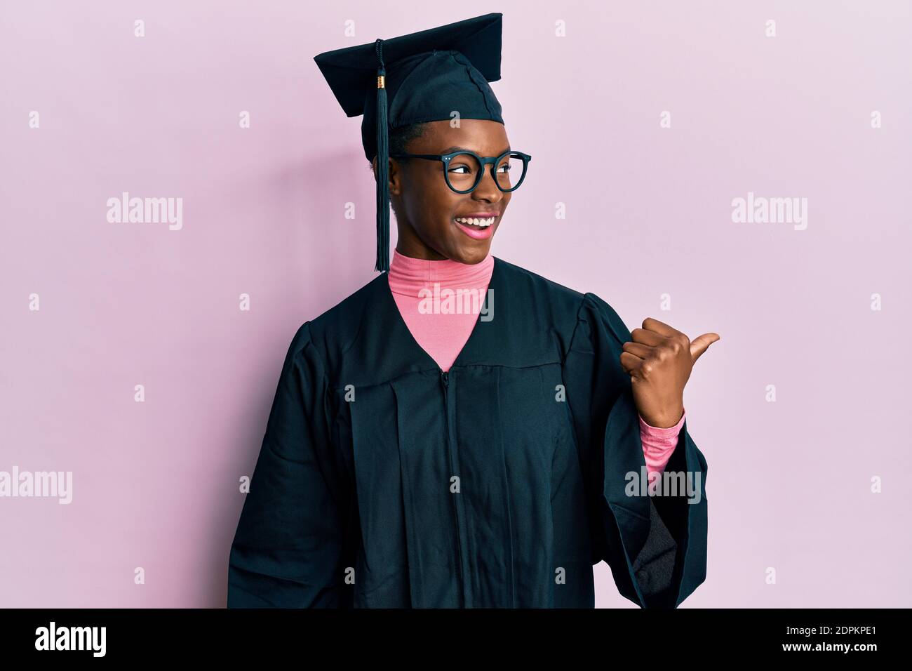 Young african american girl wearing graduation cap and ceremony robe ...