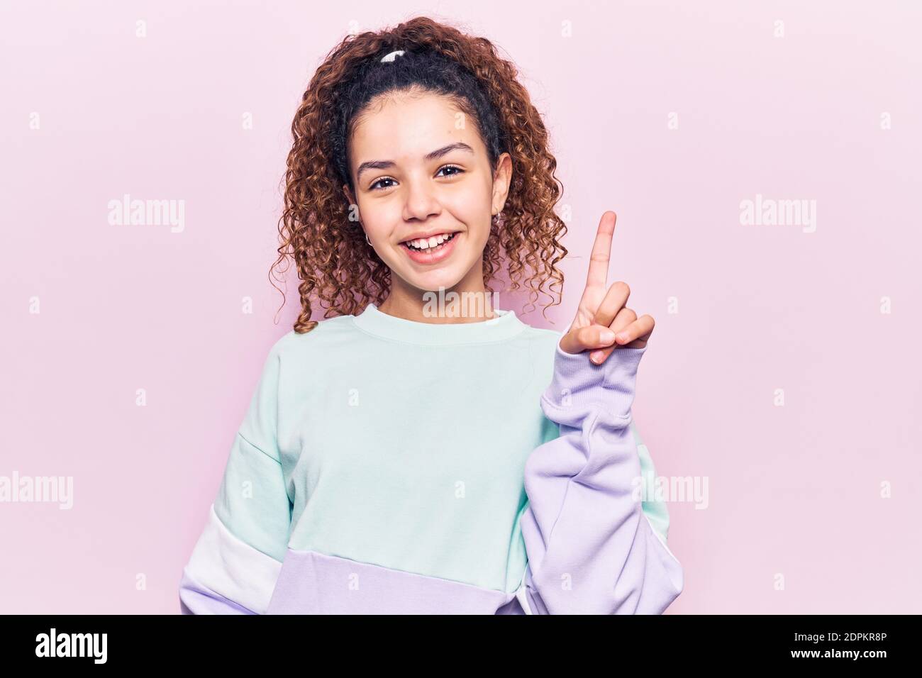 Beautiful kid girl with curly hair wearing casual sporty clothes ...