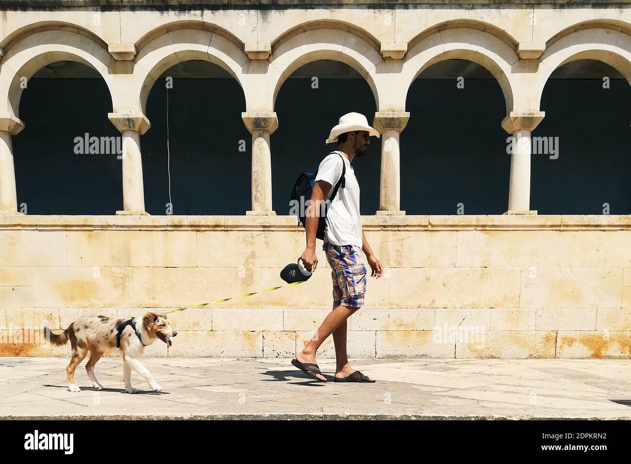 Side View Of Man With Dog Walking Against Built Structure Stock Photo ...