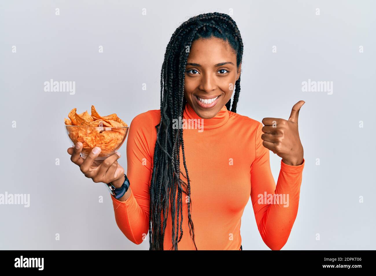 African american woman holding nachos potato chips smiling happy and ...