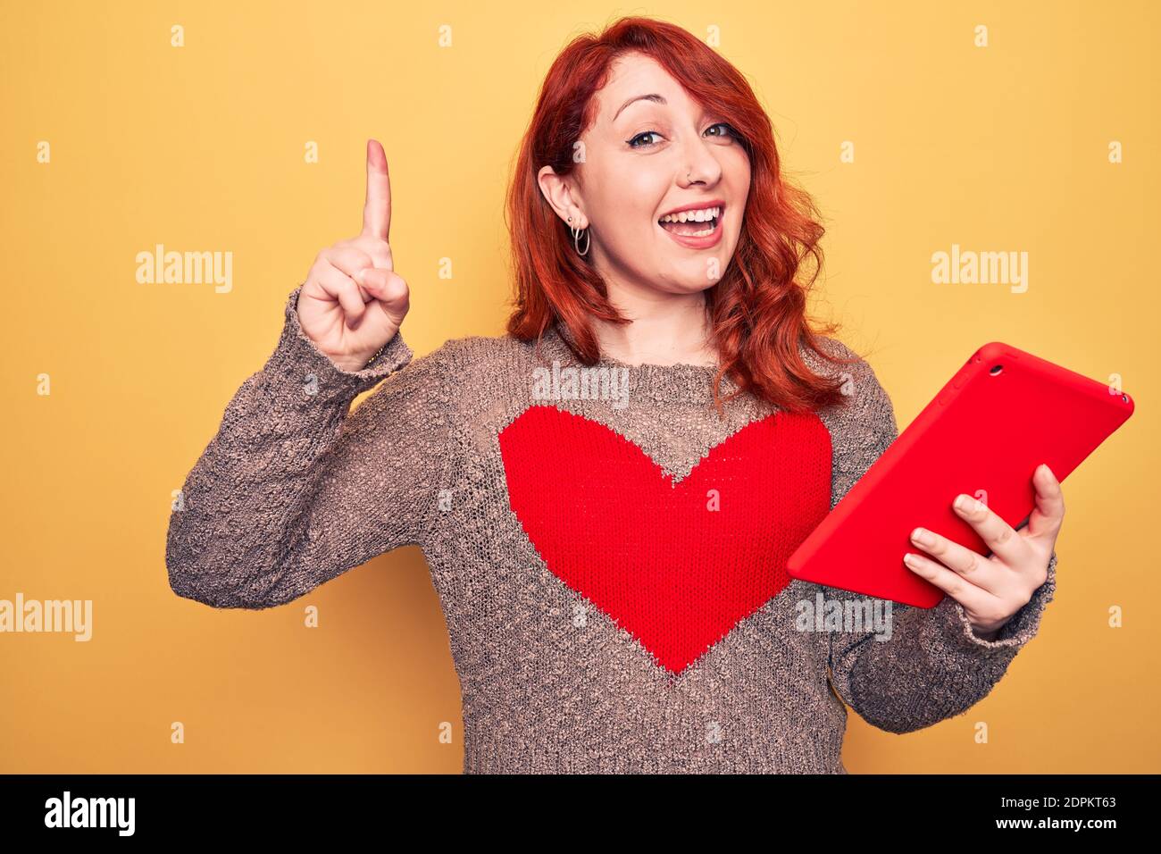 Young beautiful redhead woman using tablet standing over isolated ...