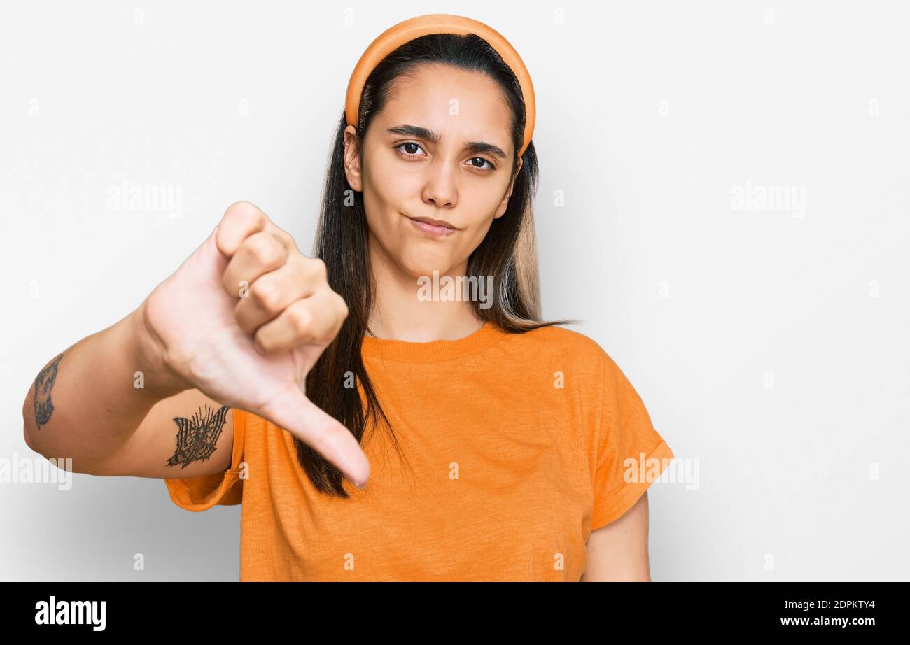 Young hispanic woman wearing casual clothes looking unhappy and angry ...