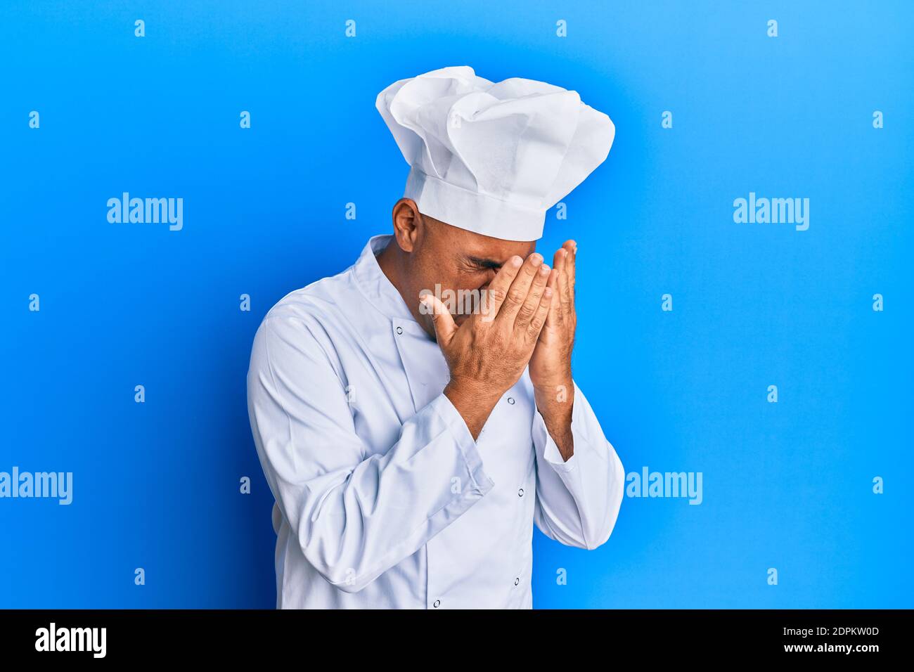 Mature middle east man wearing professional cook uniform and hat with ...