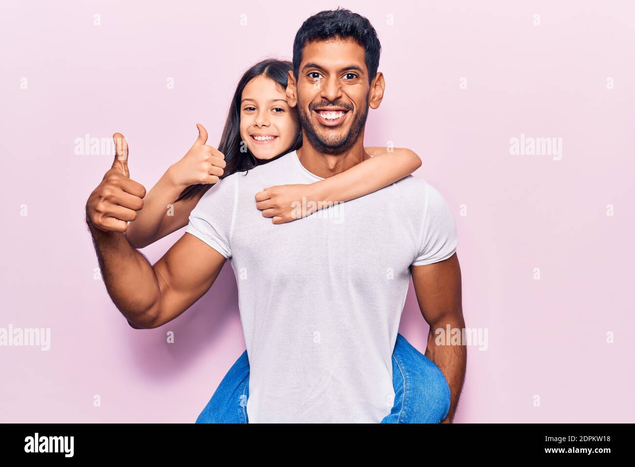 Latin father and daughter wearing casual clothes smiling happy and ...