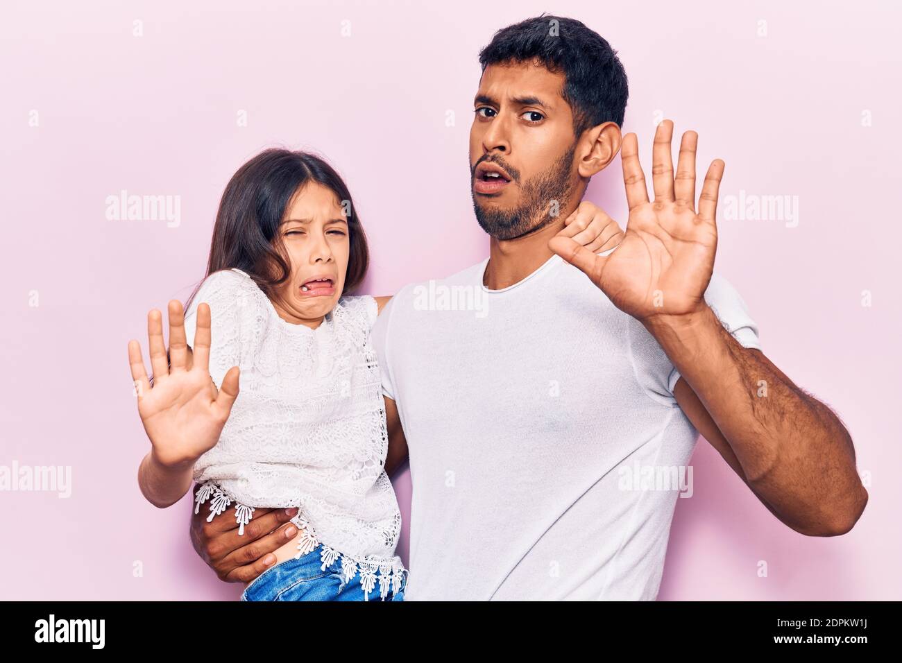 Young father and daughter wearing casual clothes afraid and terrified ...