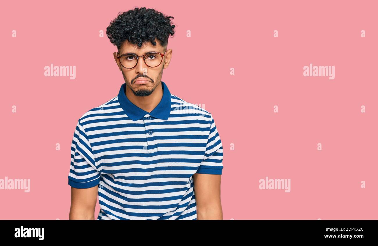 Young arab man wearing casual clothes and glasses depressed and worry ...