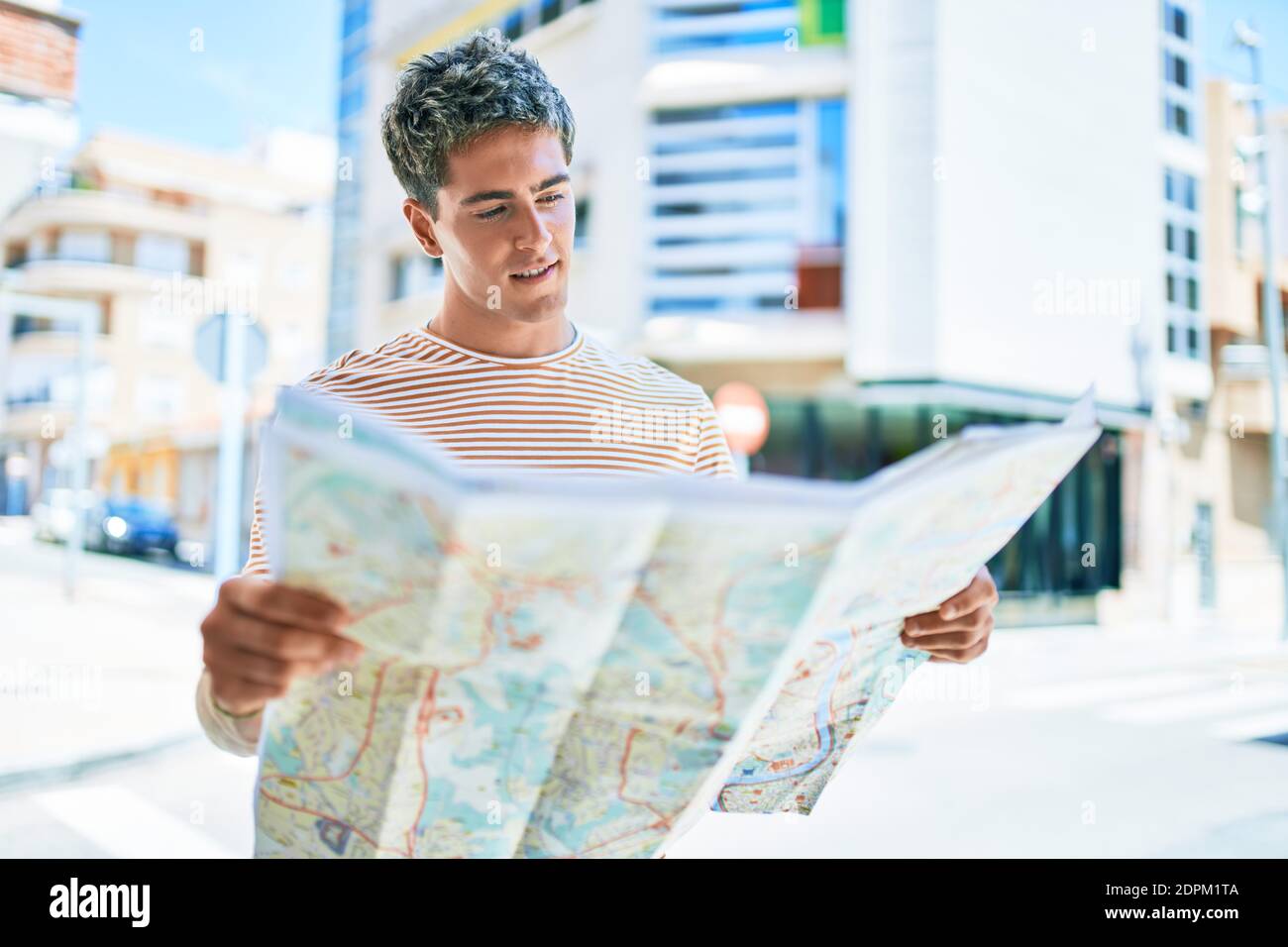 Young handsome caucasian tourist man looking city map at street Stock ...