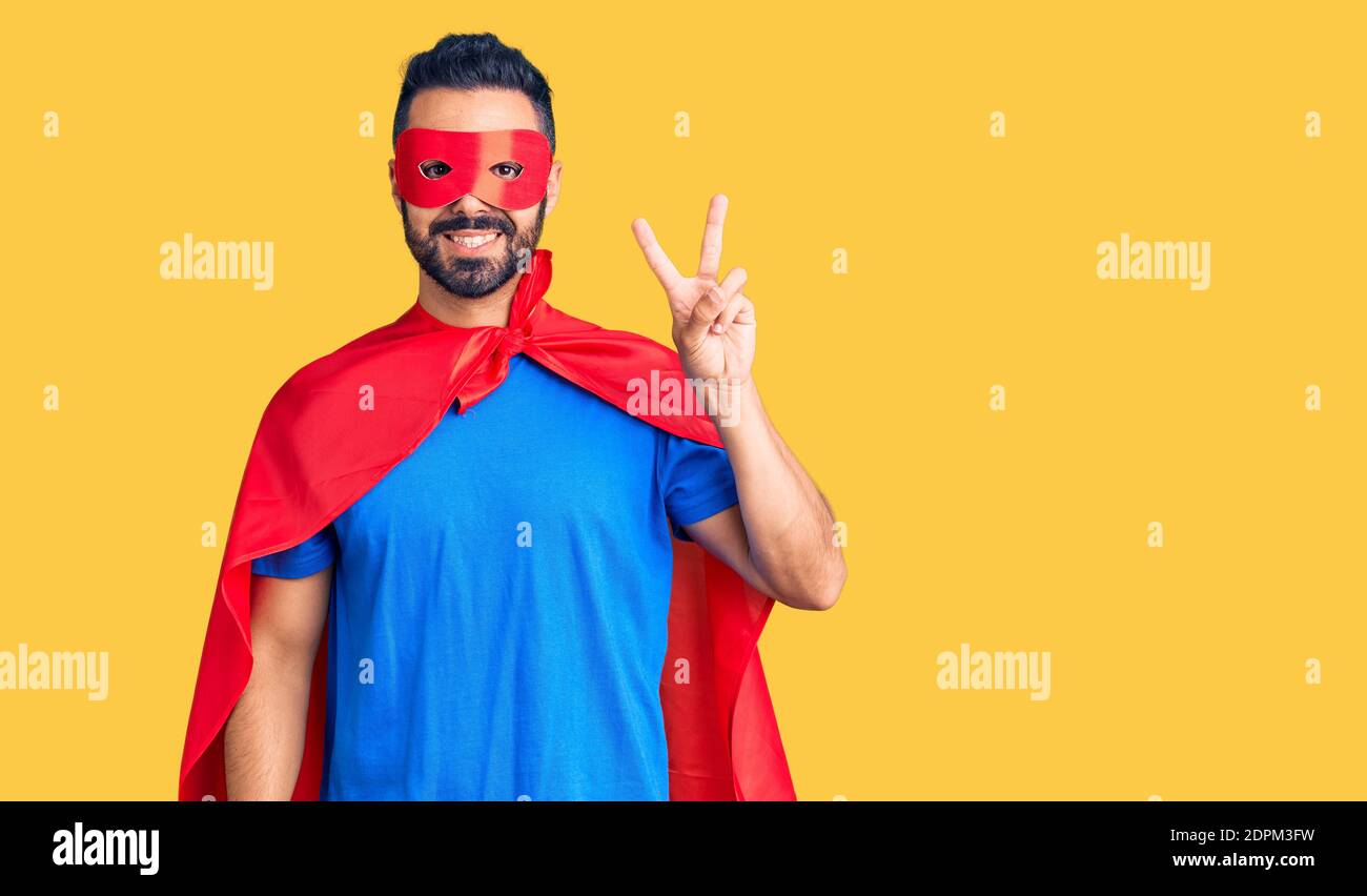 Young hispanic man wearing super hero costume smiling with happy face ...
