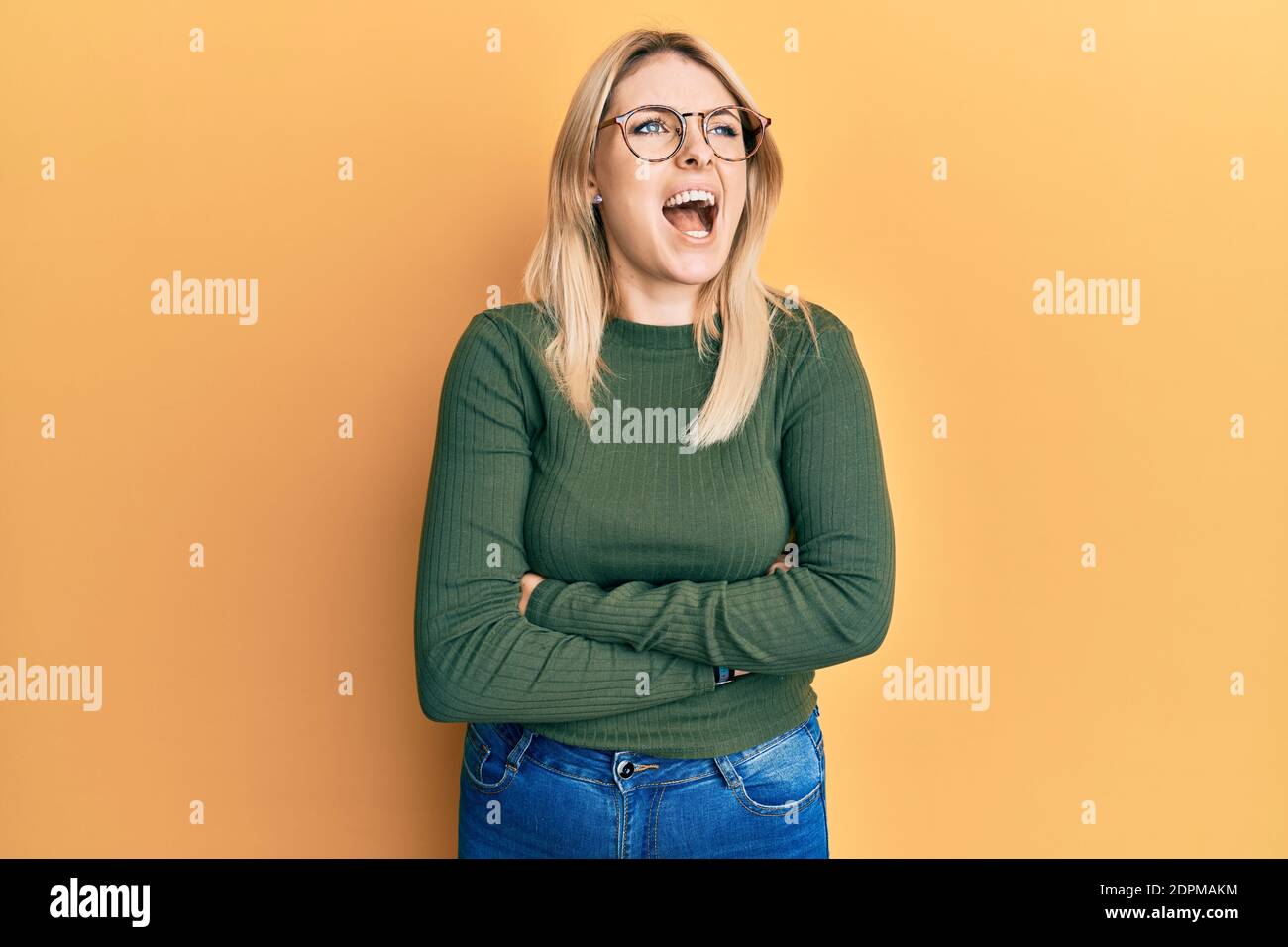 Young caucasian woman with arms crossed gesture angry and mad screaming ...