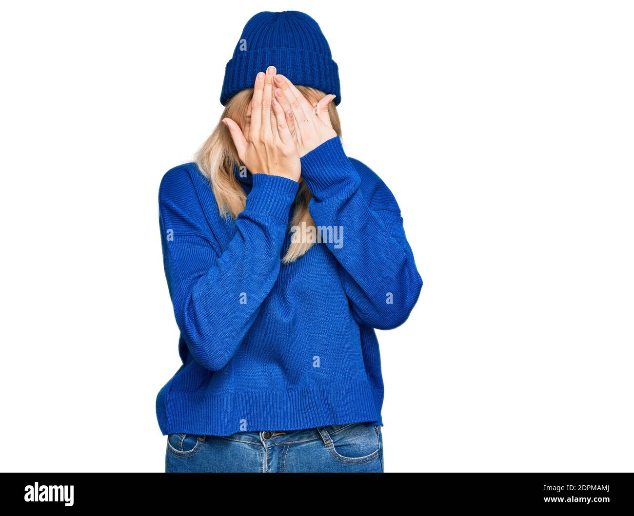 Young caucasian woman wearing wool winter sweater and cap with sad ...