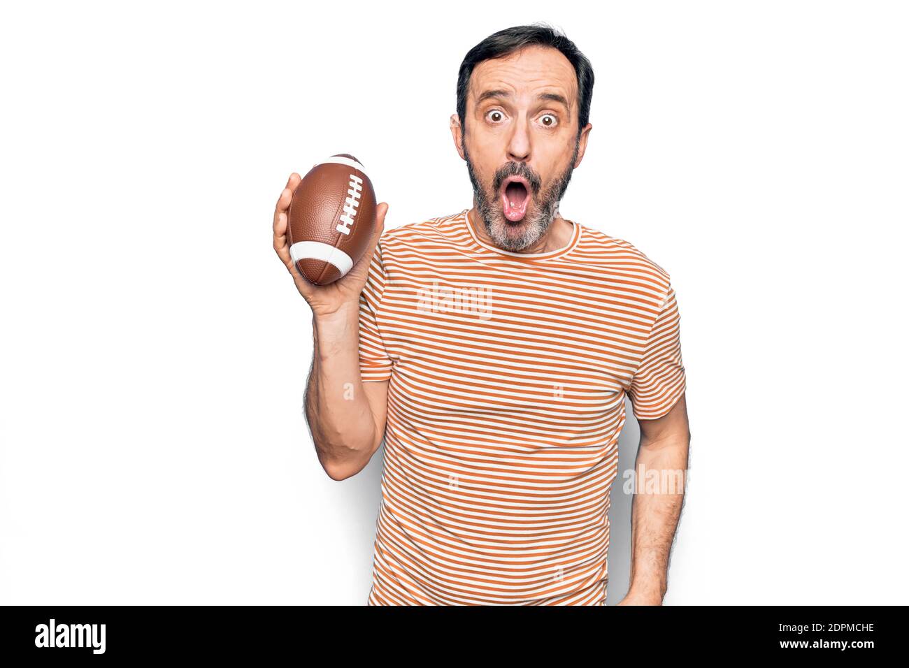 Middle age handsome player man playing football holding ball over ...