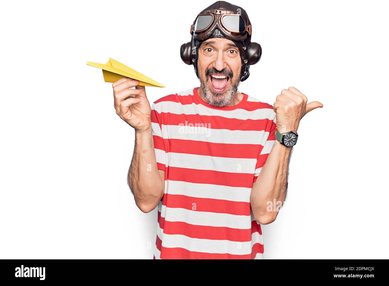 Middle age aviator man wearing vintage helmet and glasses holding paper ...