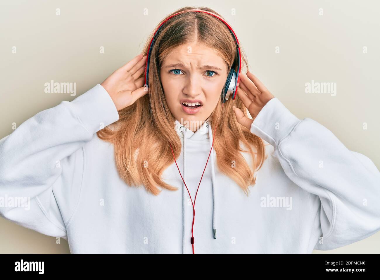 Beautiful young caucasian girl listening to music using headphones in ...