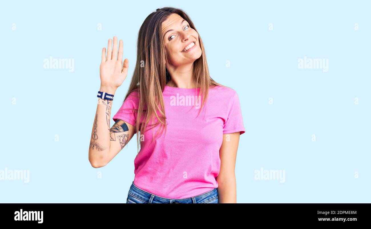Beautiful caucasian woman wearing casual clothes waiving saying hello ...