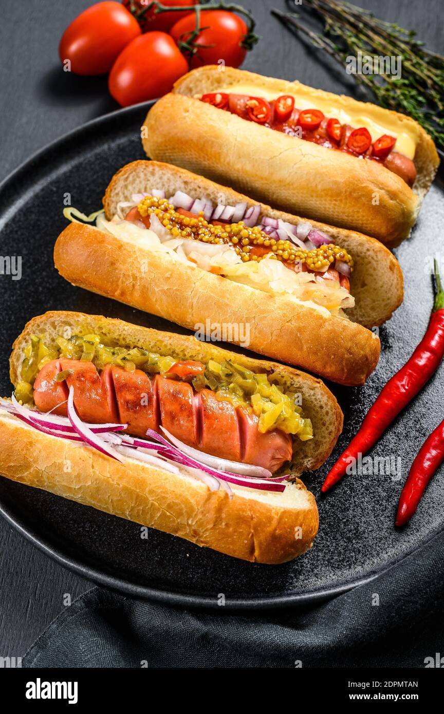 Hot dogs fully loaded with assorted toppings on a tray. Delicious hot ...